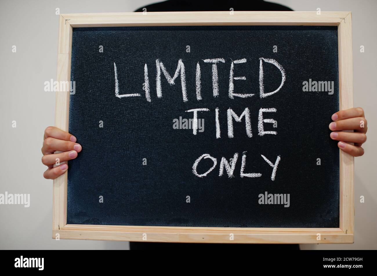 Limited time only written on blackboard. Black friday concept. Boy hold ...