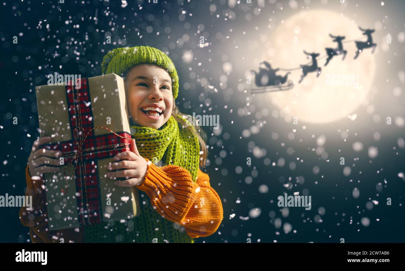 Merry Christmas! Cute little child with xmas present. Santa Claus ...
