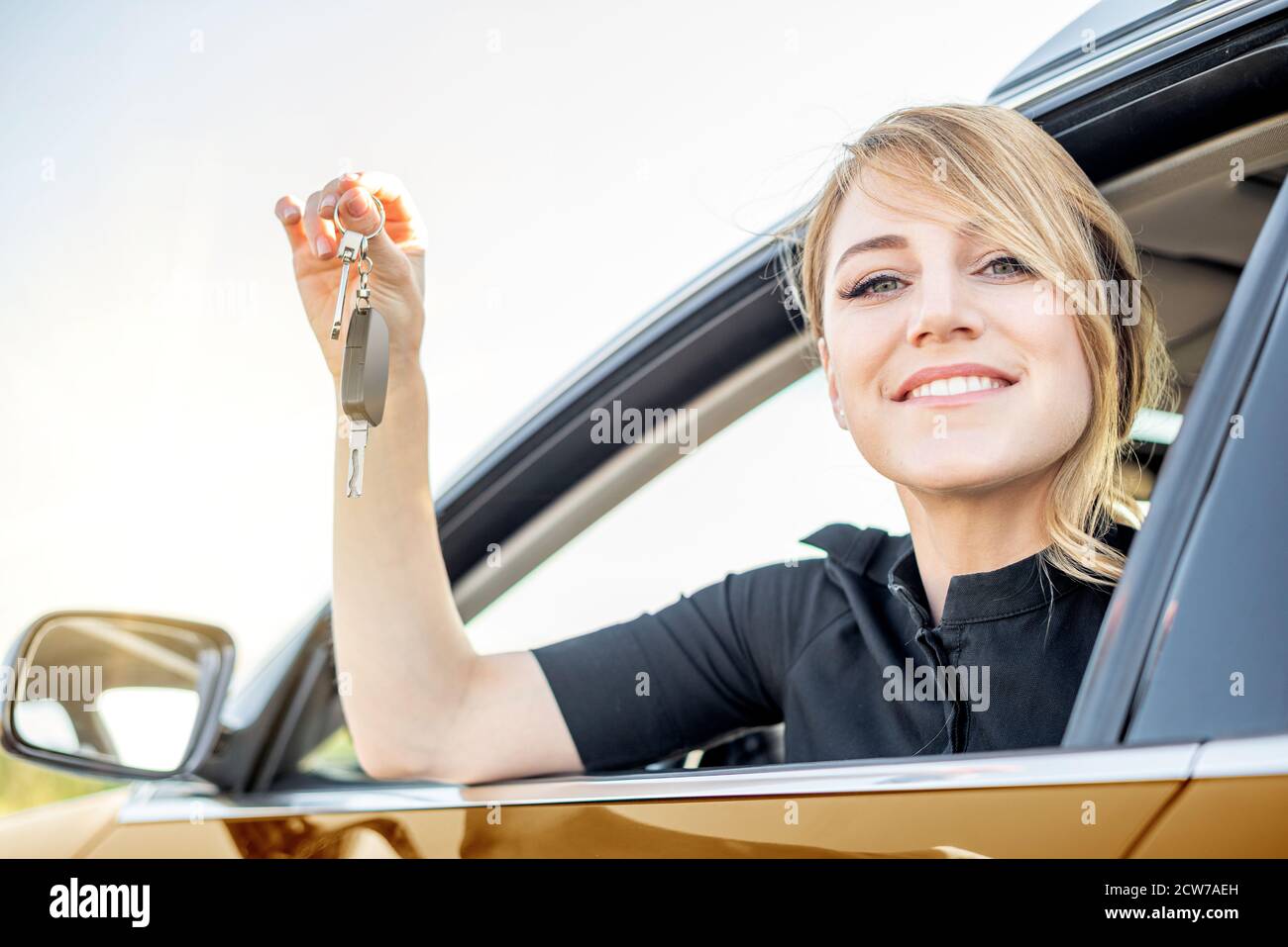Car purchase or rental. The woman driver shows the key to the car Stock ...