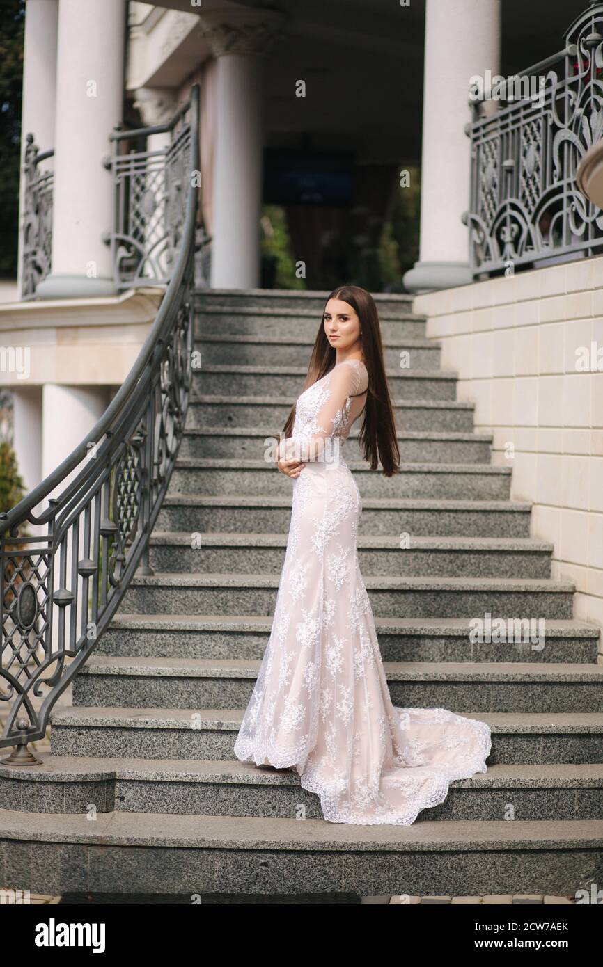 Gorgeous model in wedding dress stand on stair by big restaurant Stock ...