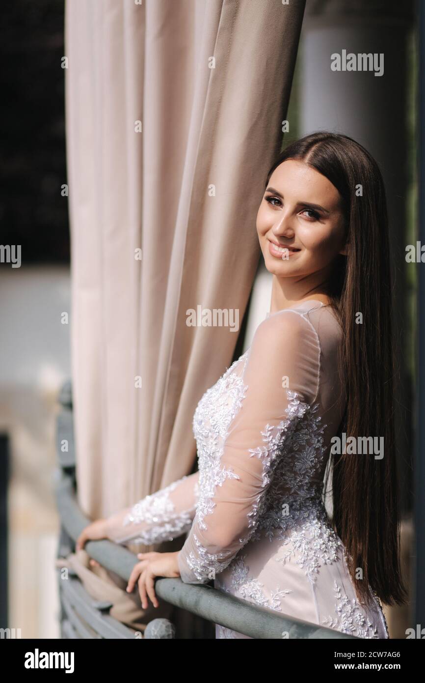Beautiful young model in evening drees posing to photographer by the ...