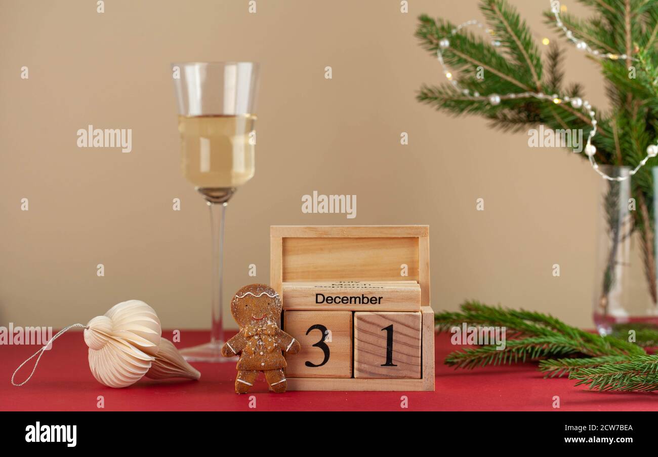 Wooden calendar on December 31 with a gingerbread man, a glass of ...