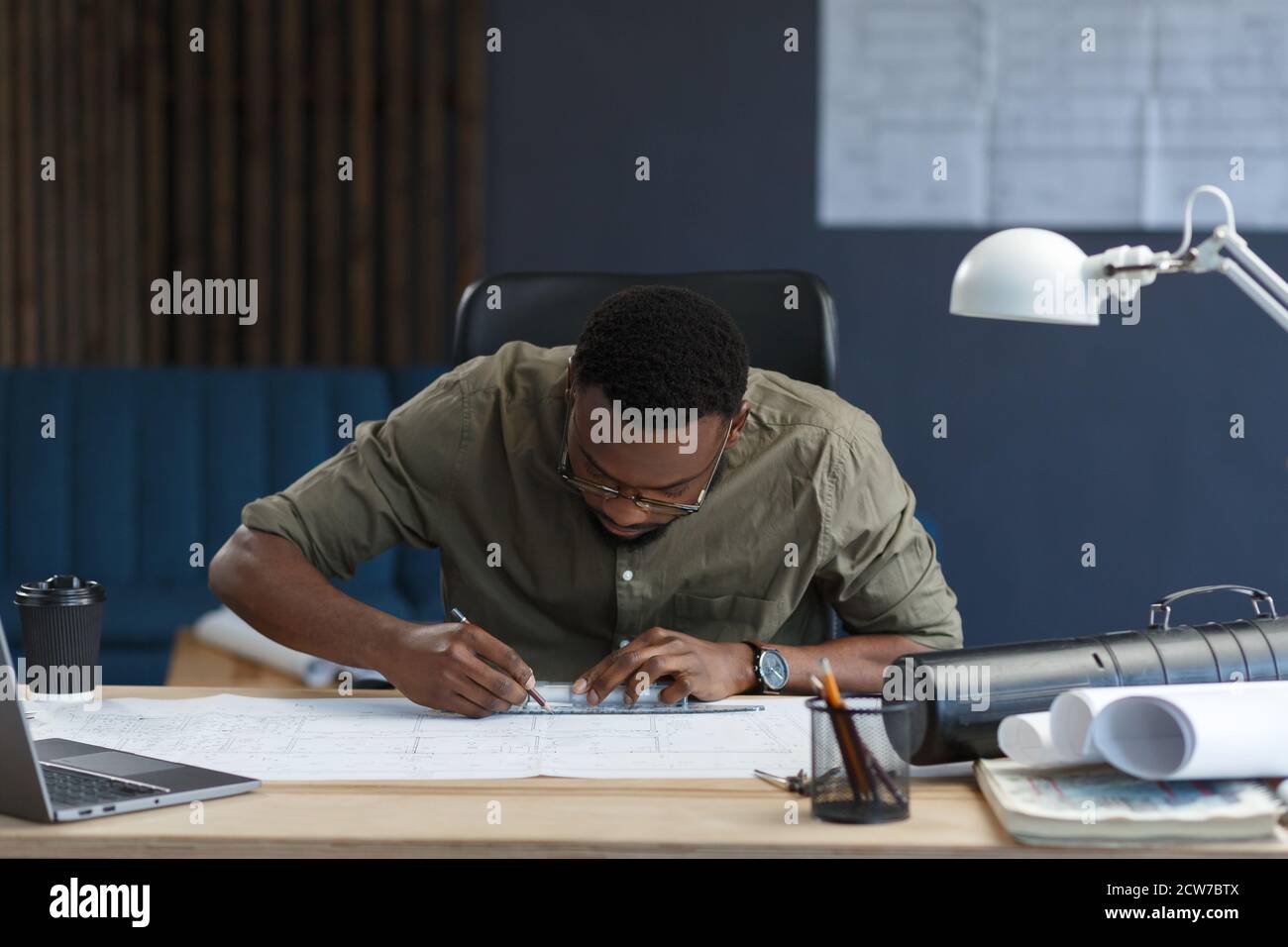 Afro-American architect working in office with blueprints.Engineer ...