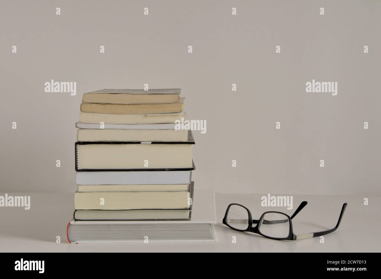 Stack of books, books of various themes, reading glasses, side view ...