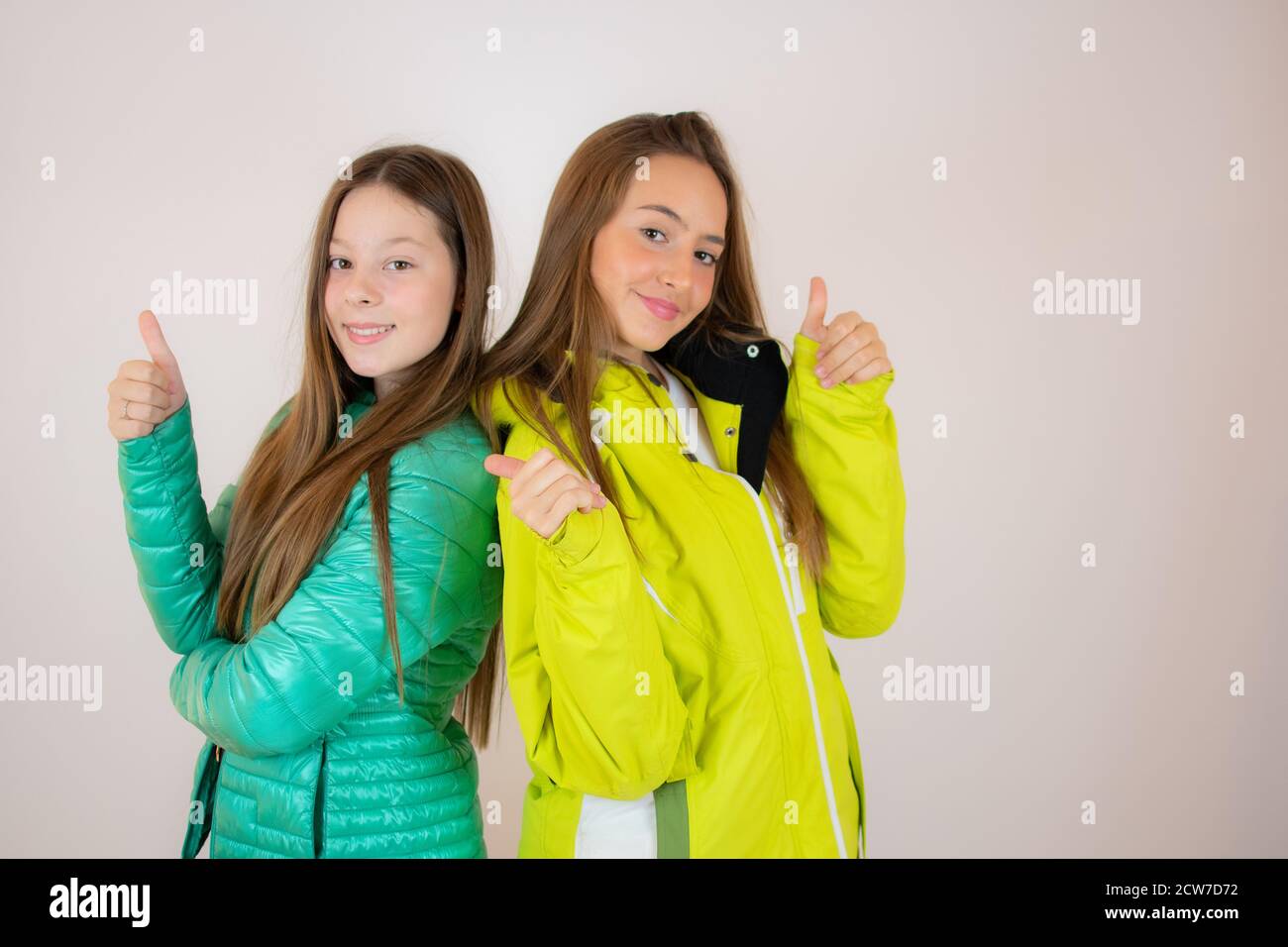 Two smiling friends in winter jackets on white background Stock Photo ...
