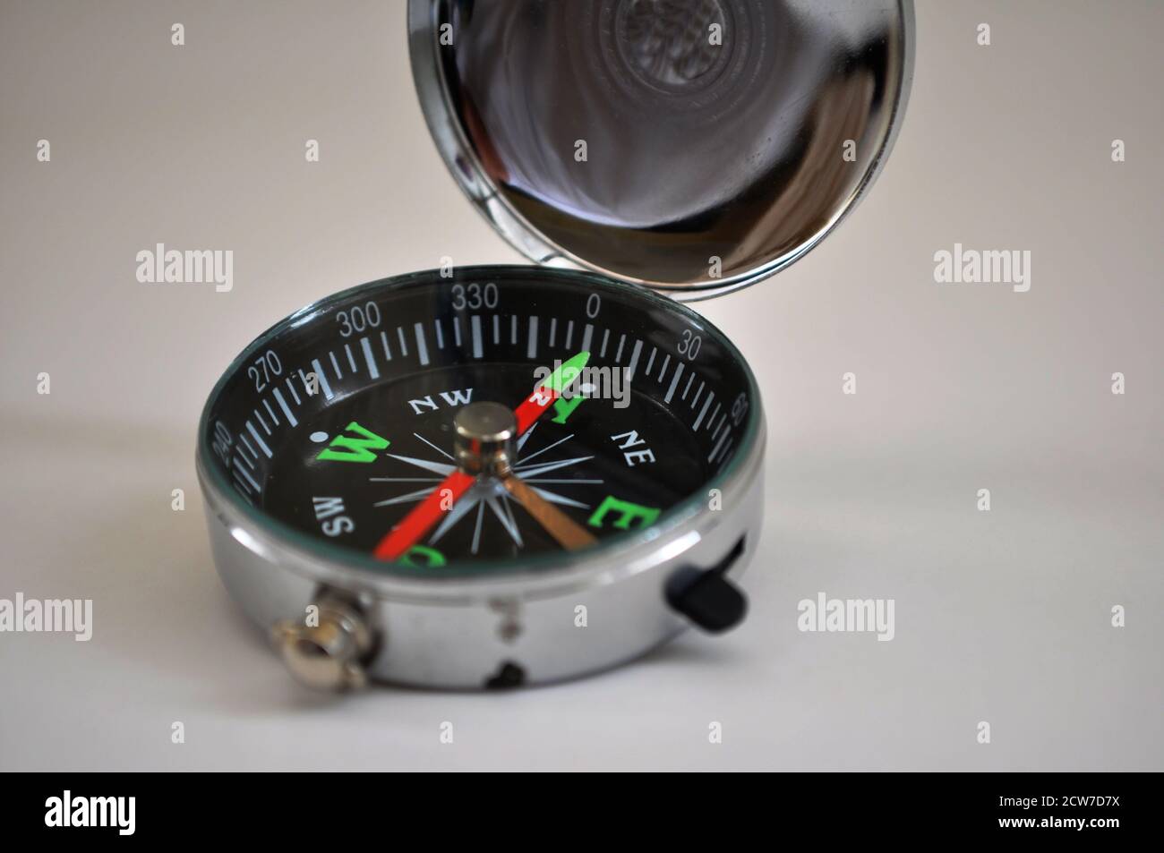 Metal compass with colorful showing some black cardinal points on white ...