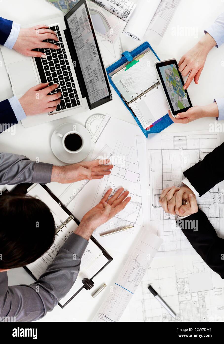 People reviewing blueprints at desk Stock Photo - Alamy