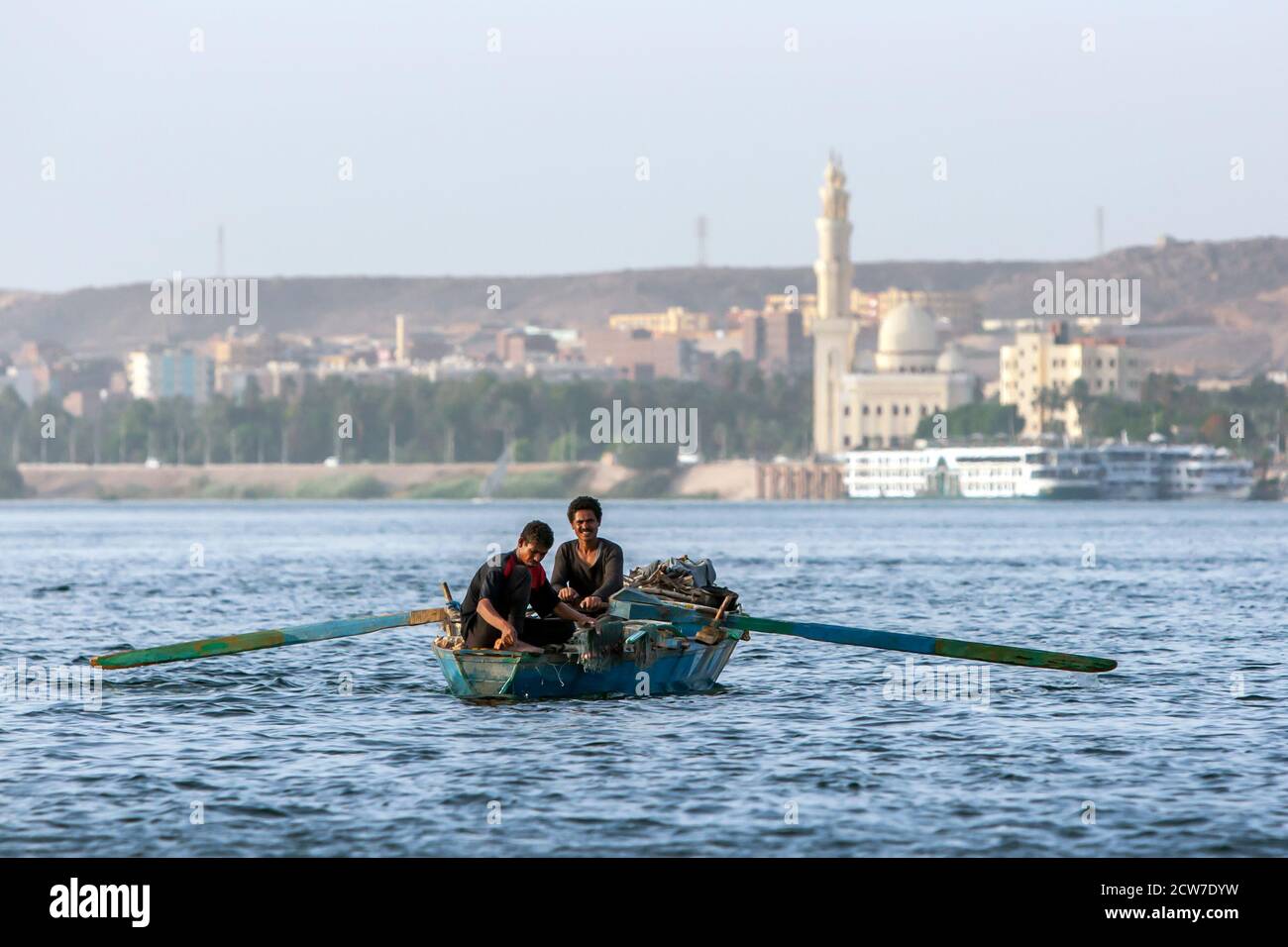 Egyptian men row their fishing boat along the River Nile at Aswan in ...
