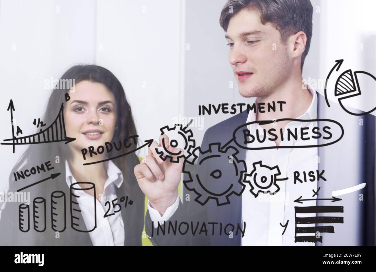 Co-workers drawing on whiteboard Stock Photo - Alamy