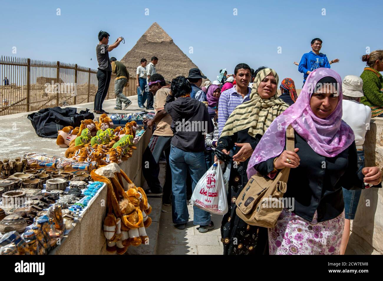 A crowd of tourists to Giza in Cairo, Egypt gather near the base of the ...