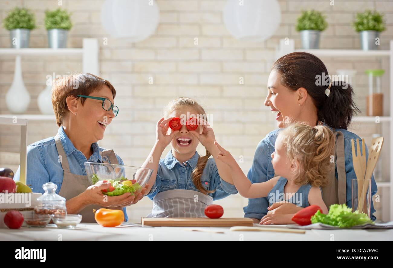 Healthy food at home. Happy family in the kitchen. Grandma, mother and ...