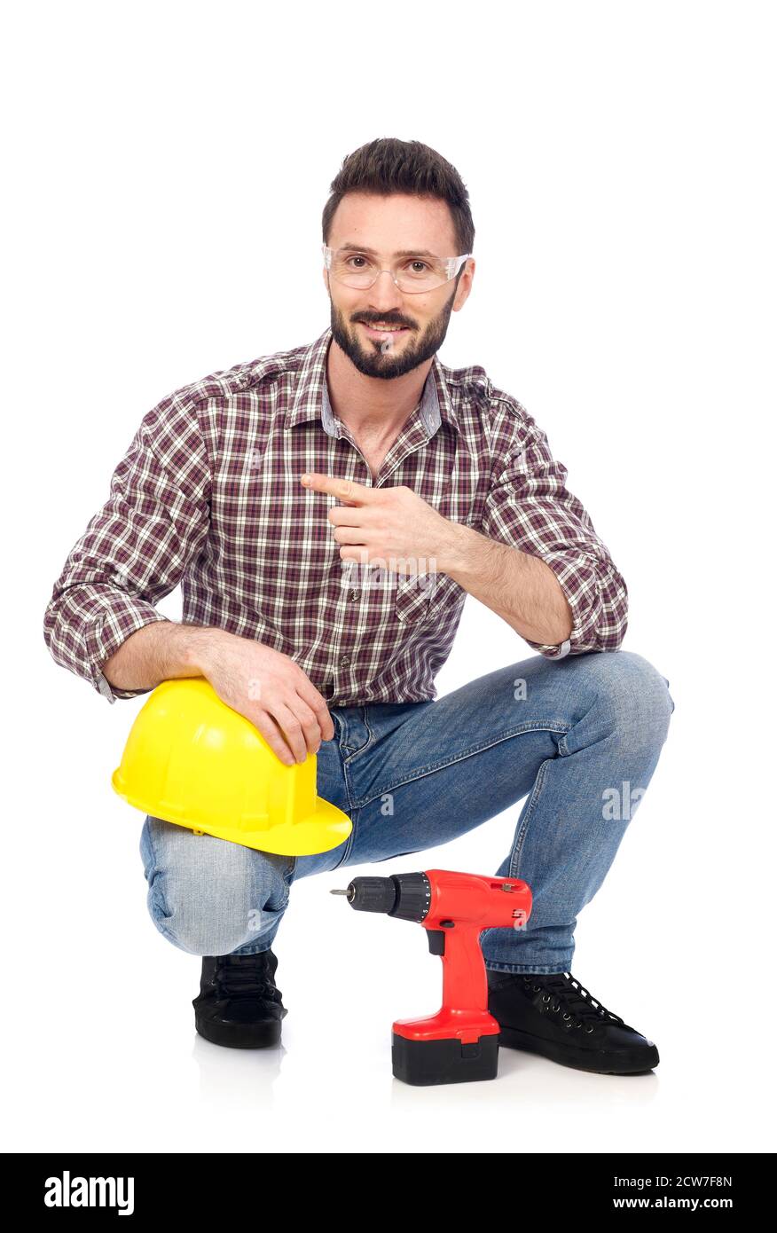 Cheerful carpenter looking at camera and pointing, white background ...