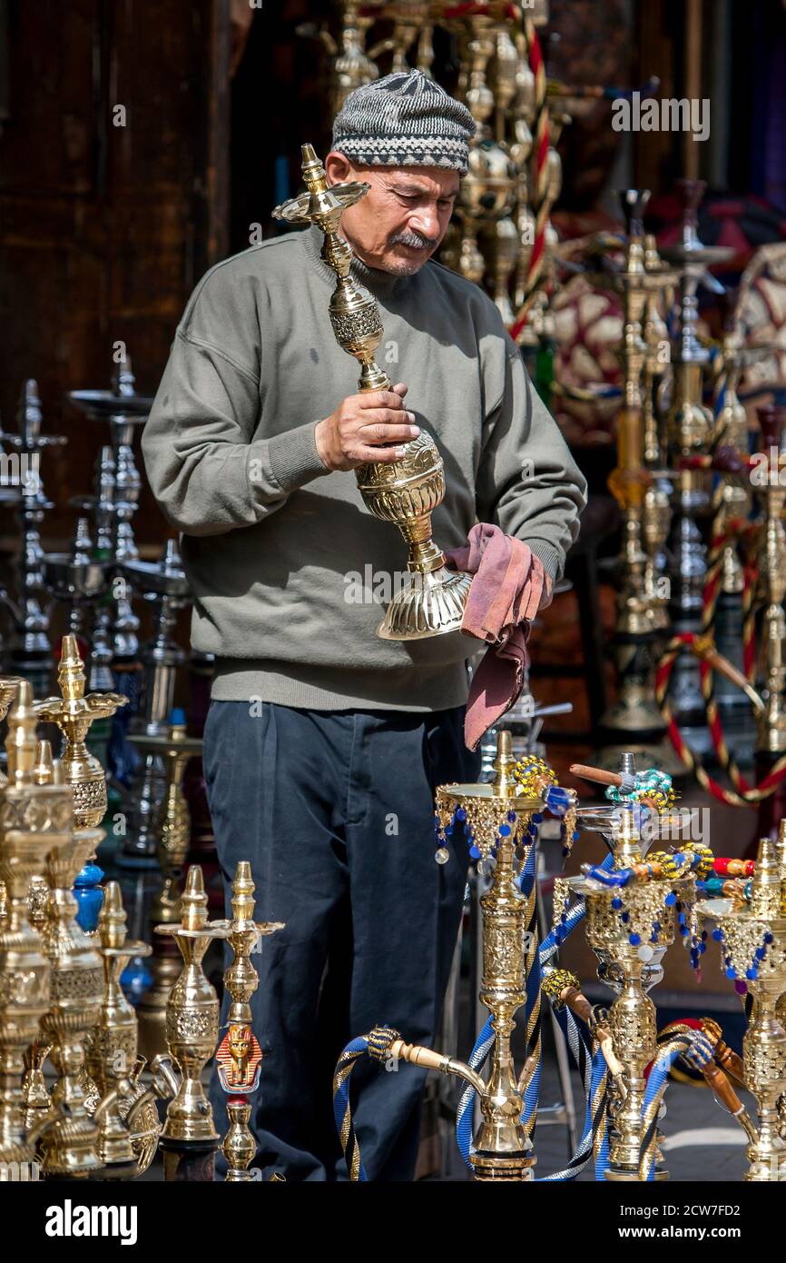 A shop owner at the Khan el Khal'ili Bazaar in Cairo, Egypt cleans one ...