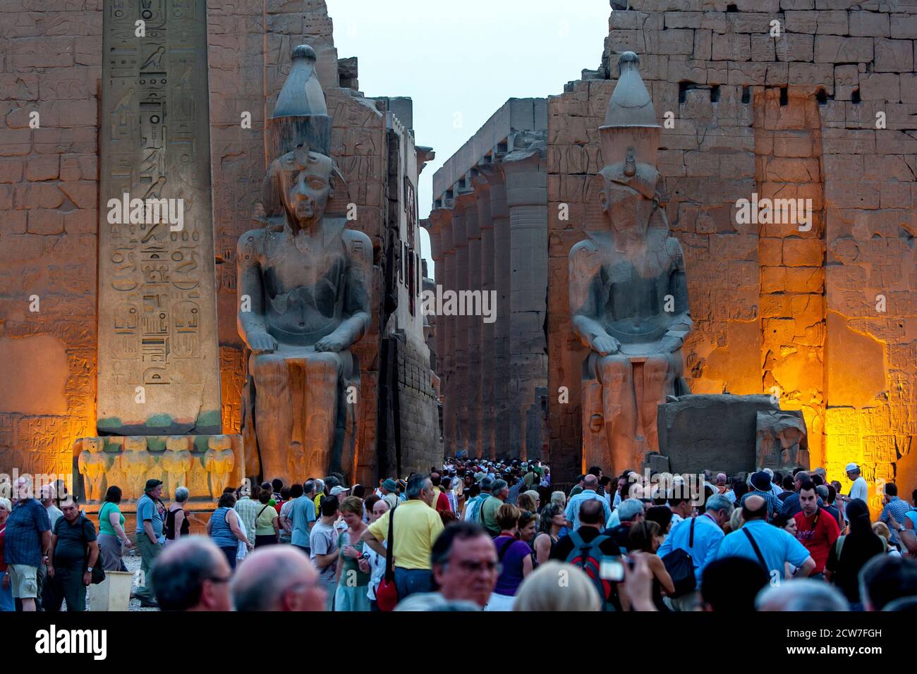 A crowd of tourists gather at the entrance pylon of the Luxor Temple ...