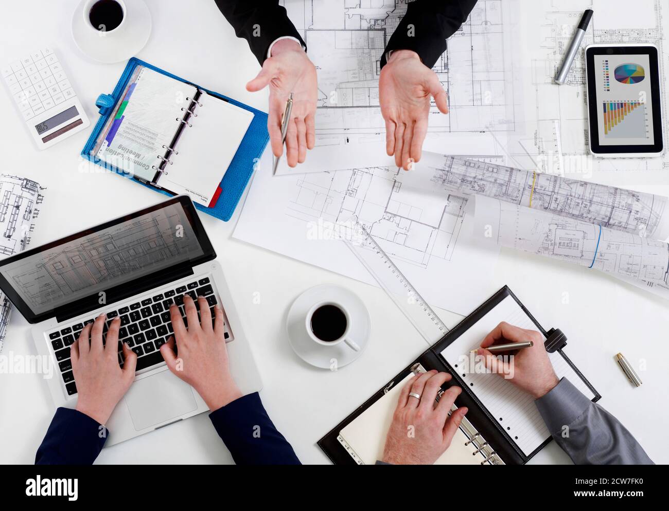People reviewing blueprints at desk Stock Photo - Alamy