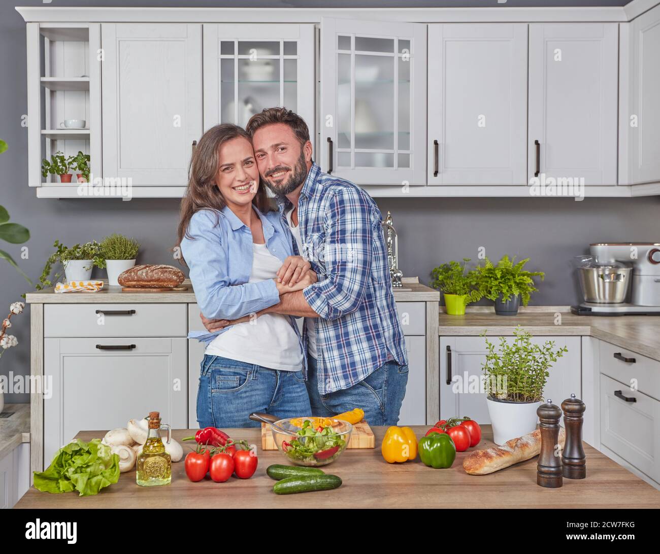 Happily married couple cooking together in the kitchen Stock Photo - Alamy
