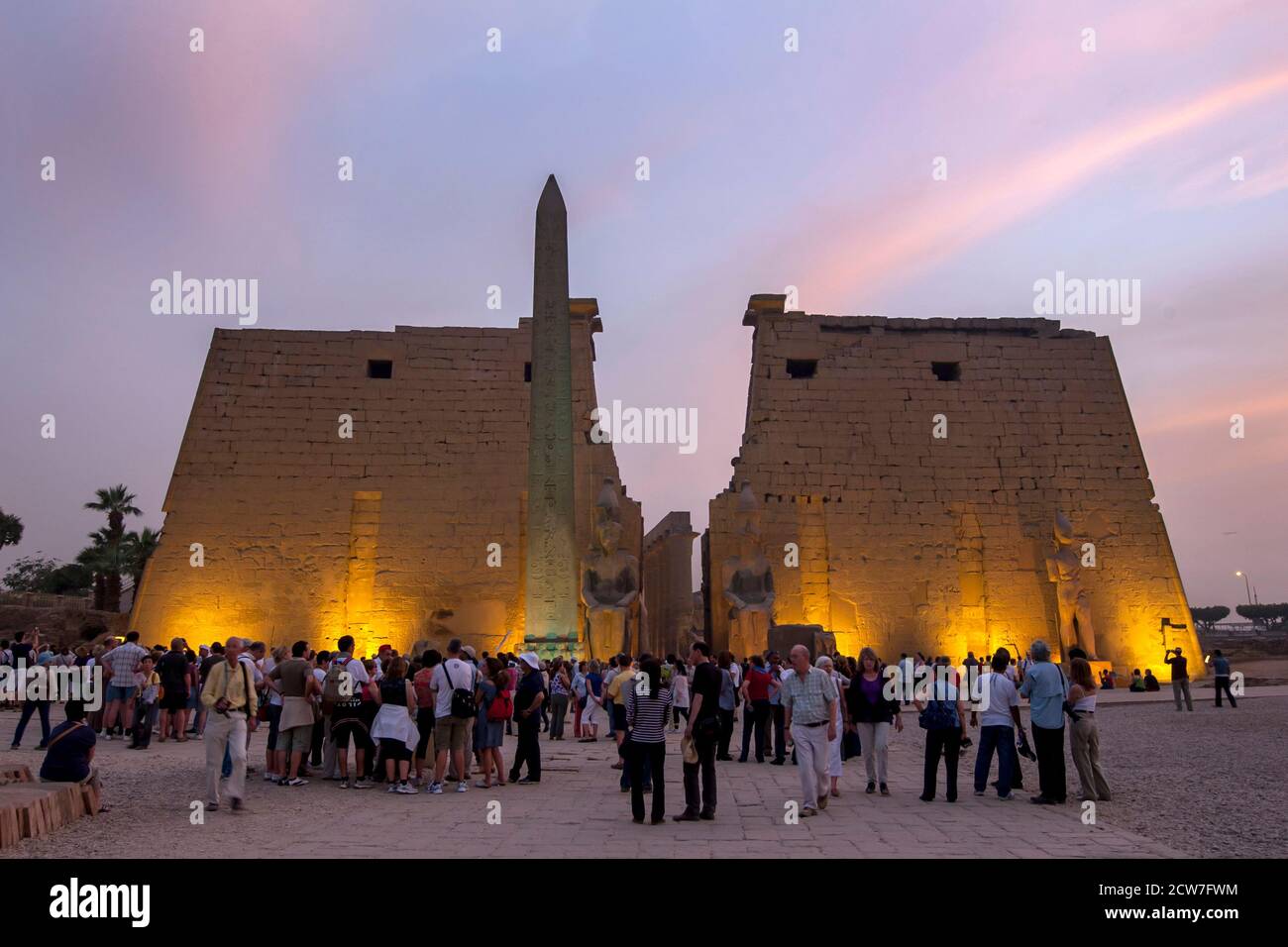 A crowd of tourists gather at the entrance pylon of the Luxor Temple ...