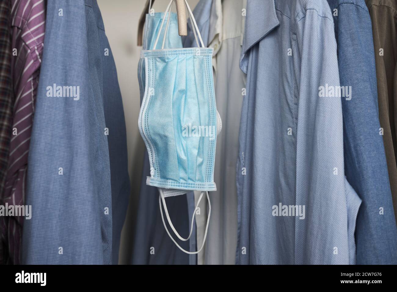 Different protective face masks hanging with clothes Stock Photo - Alamy