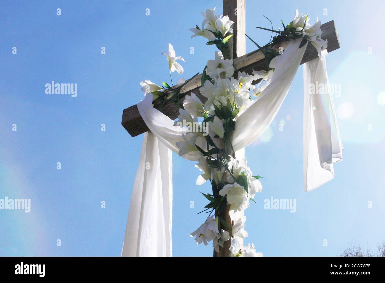 White drape and white lilies (symbols of the Resurrection) over a cross ...