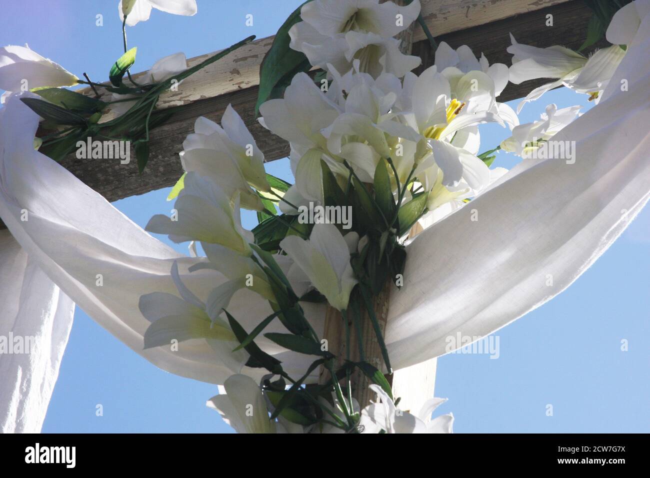White drape and white lilies (symbols of the Resurrection) over a cross ...