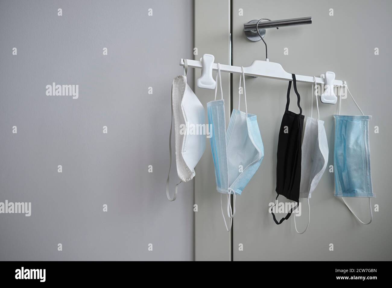 Different protective face masks hanging with clothes Stock Photo - Alamy