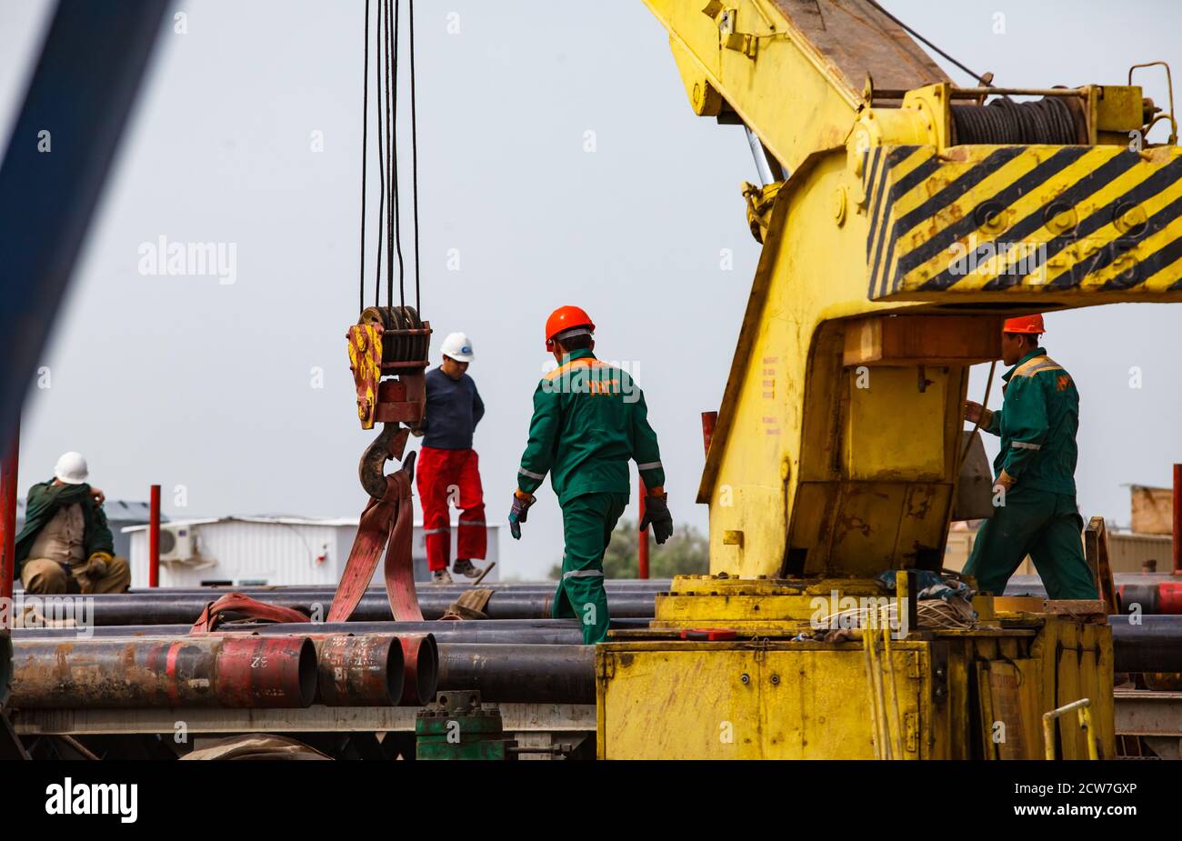 Oil deposit. Working moment on oil drilling rig. Yellow crane, rust ...
