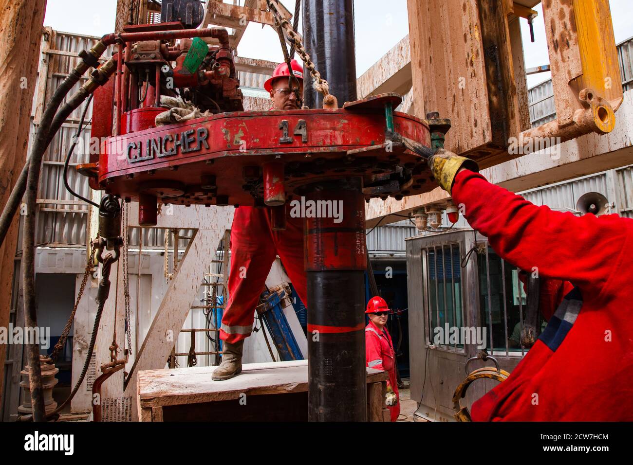 Works on drilling rig. Oil workers in Weatherford company red work wear ...