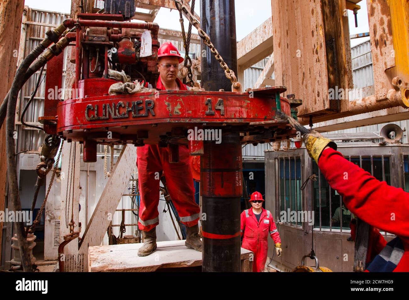 Workers in Weatherford company red work wear and red helmets with ...