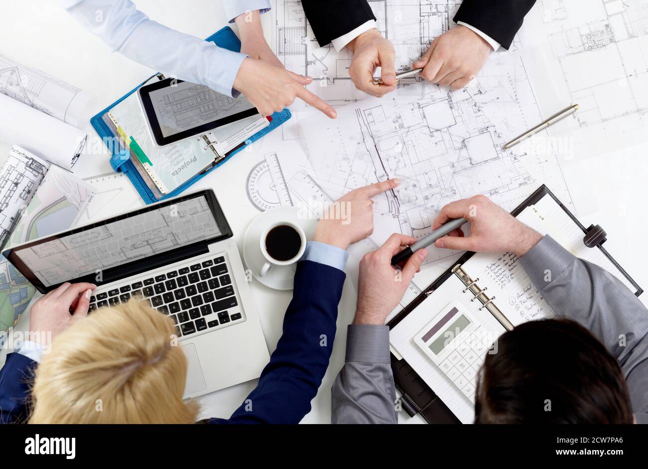 People reviewing blueprints at desk Stock Photo - Alamy
