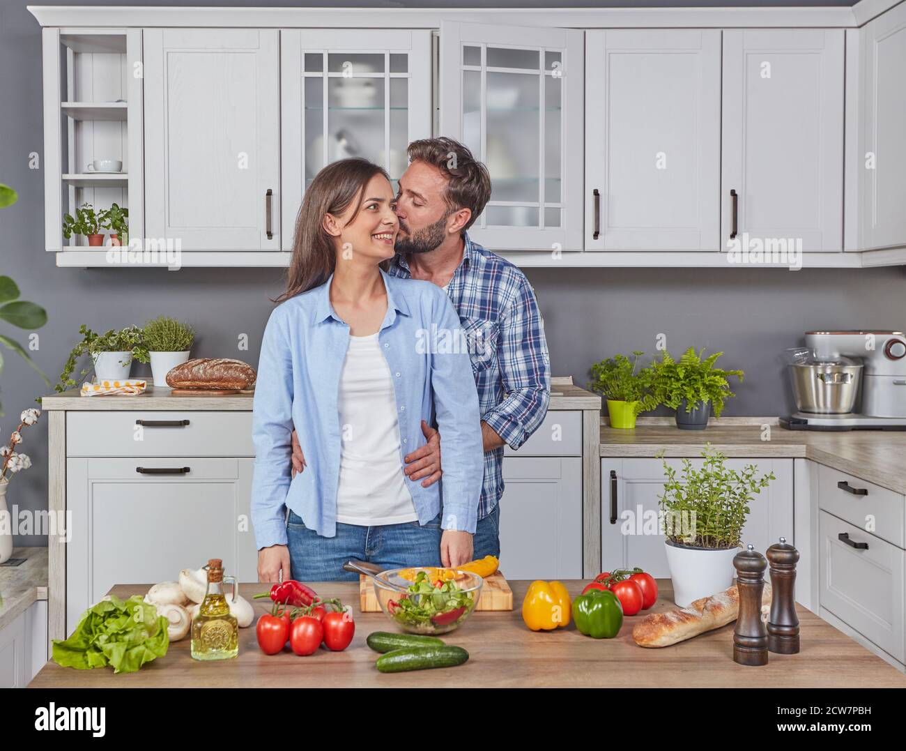 Happily married couple cooking together in the kitchen Stock Photo - Alamy