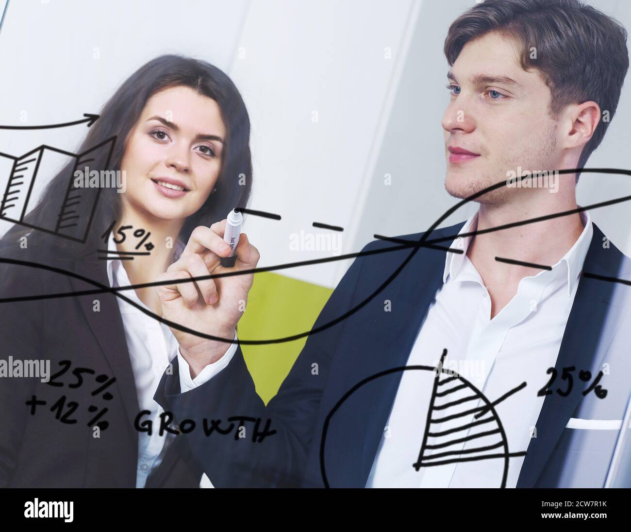 Co-workers drawing on whiteboard Stock Photo - Alamy