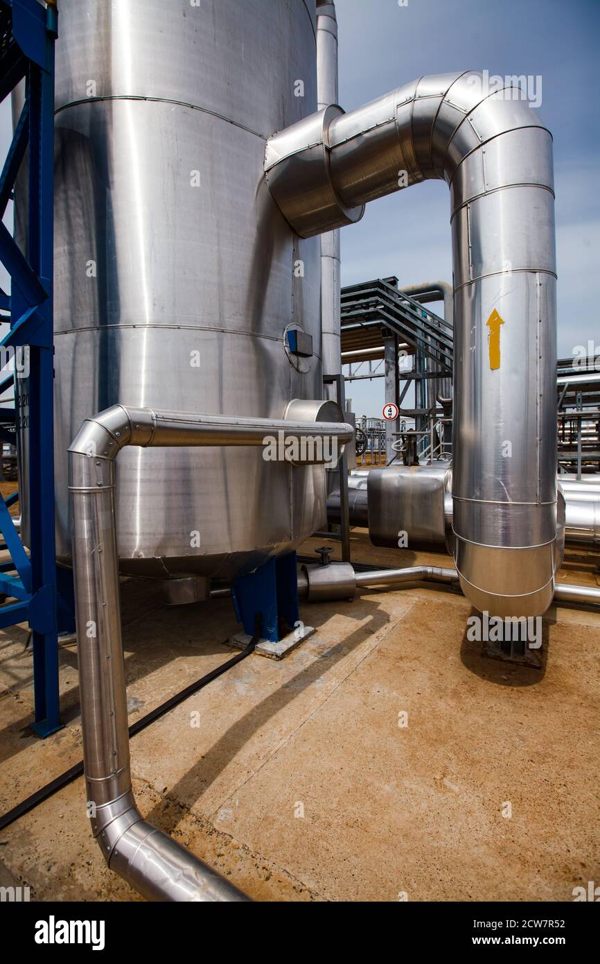 Oil refinery plant. Close-up of refinery tank, pipes and pipelines ...