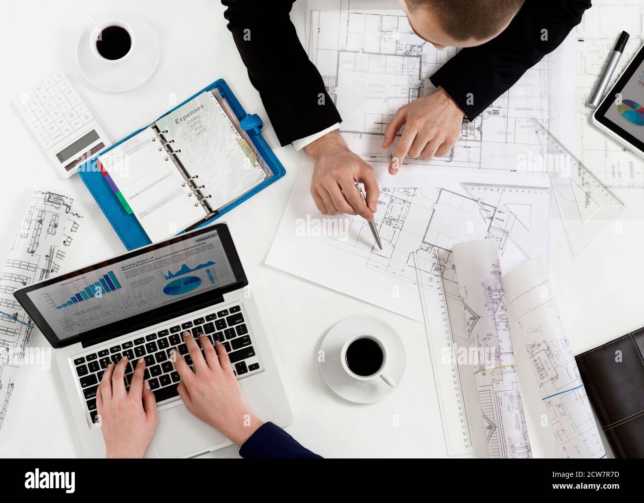 People reviewing blueprints at desk Stock Photo - Alamy