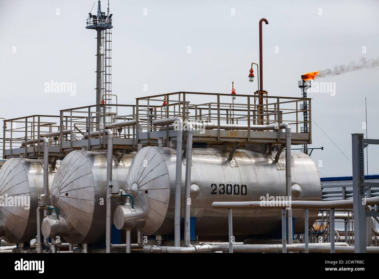 Oil refinery plant. Heat exchangers, lighting mast, platforms and ...