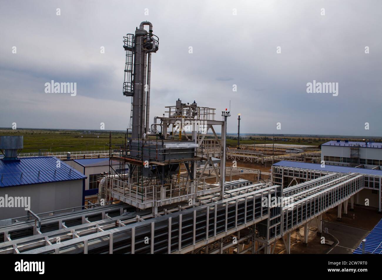 Oil refinery plant on grey sky background. Distillation tower and ...