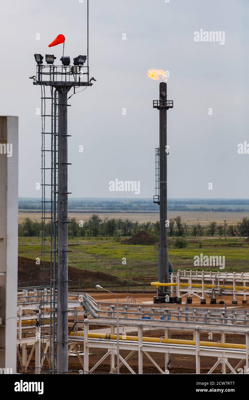 Oil refinery or gas processing plant. Black pipe with burning gas torch ...