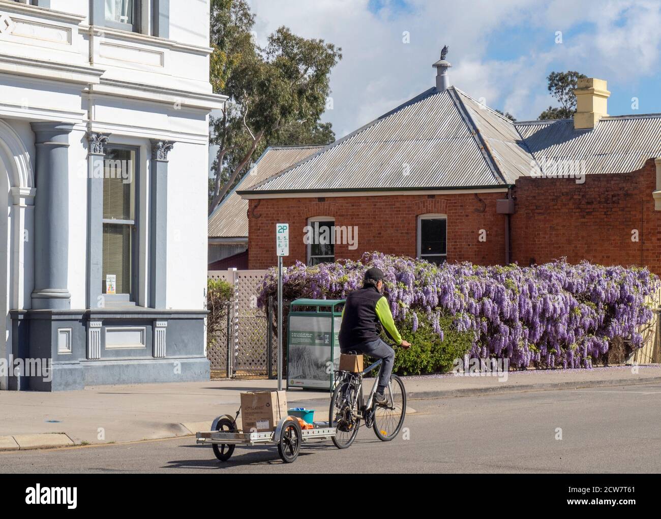 Male cyclist riding a bicycle pulling a loaded bike trailer on Avon ...