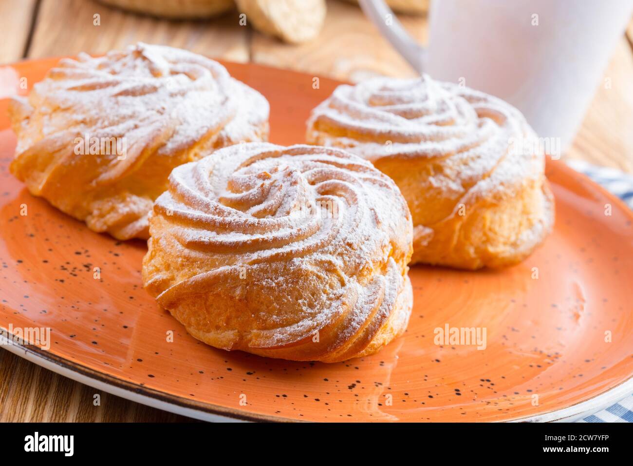 Small french cookies profitroles with sugar powder Stock Photo - Alamy