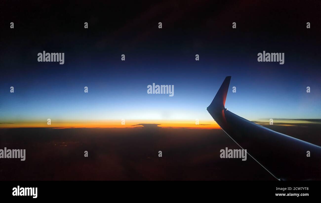 Blue orange sunset from a sky height. Airplane wing Stock Photo - Alamy