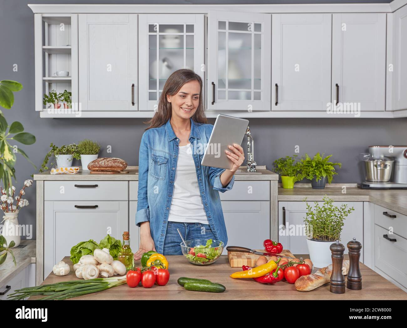 Woman making salad using tablet hi-res stock photography and images - Alamy