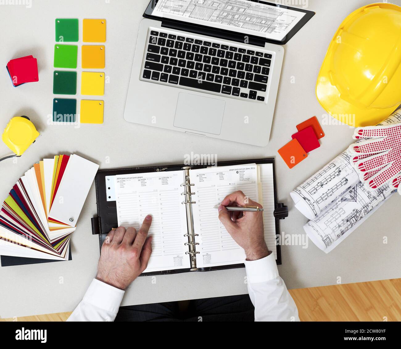 Man working on construction papers at desk Stock Photo - Alamy