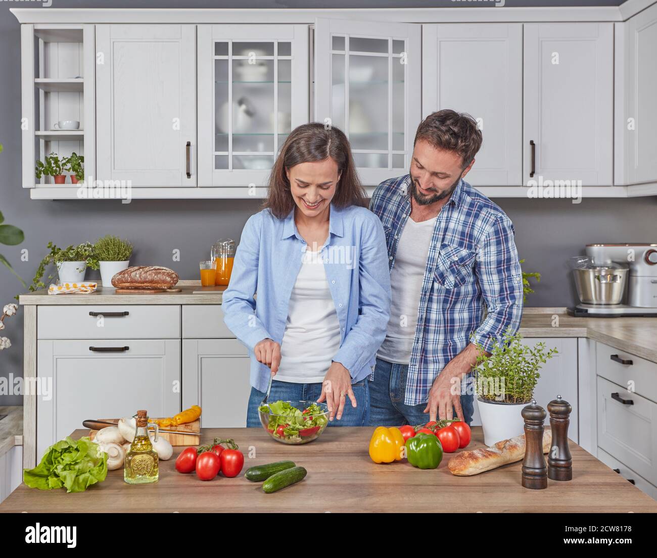Happily married couple cooking together in the kitchen Stock Photo - Alamy