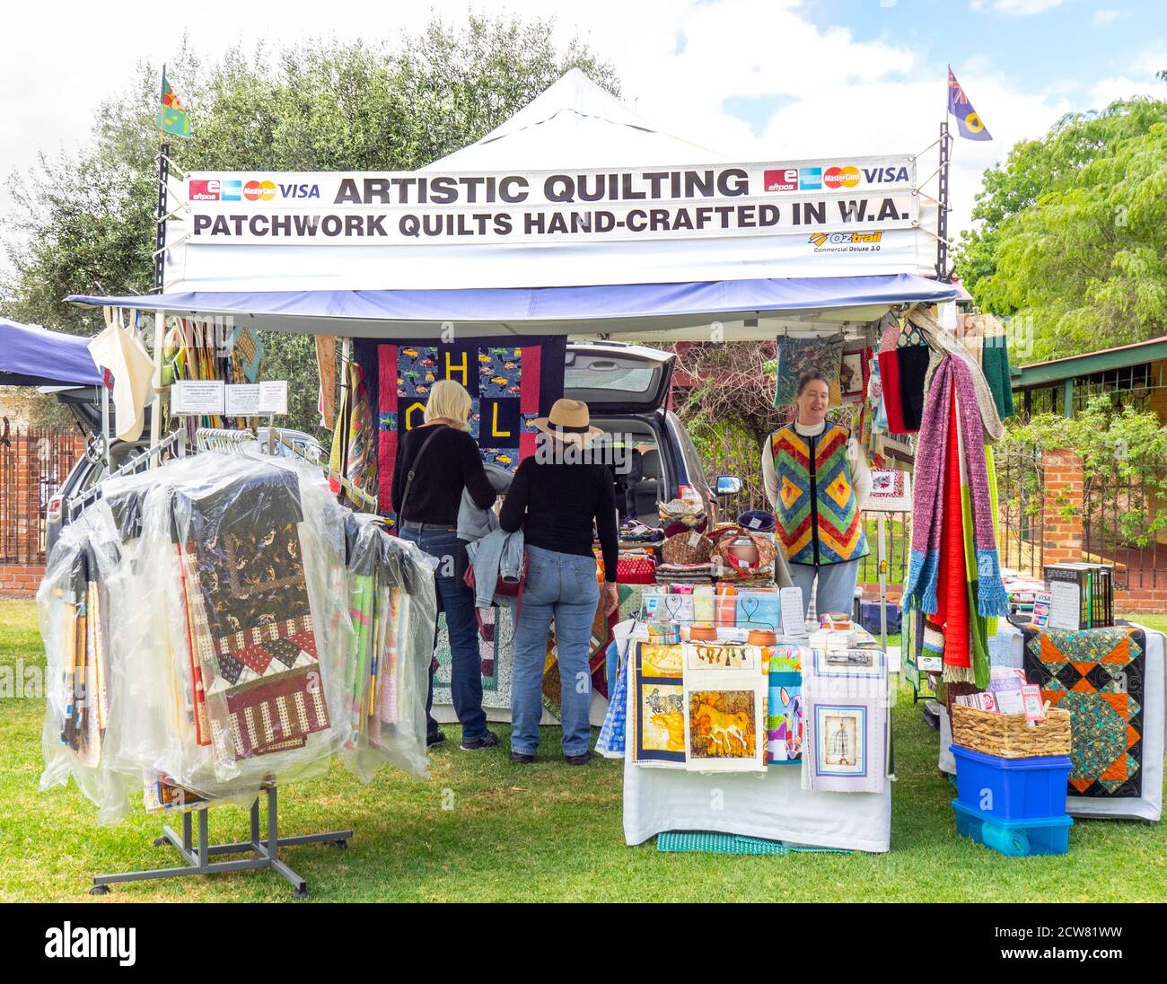 Two women browsing at a patchwork and quilt stall at outdoor markets in ...