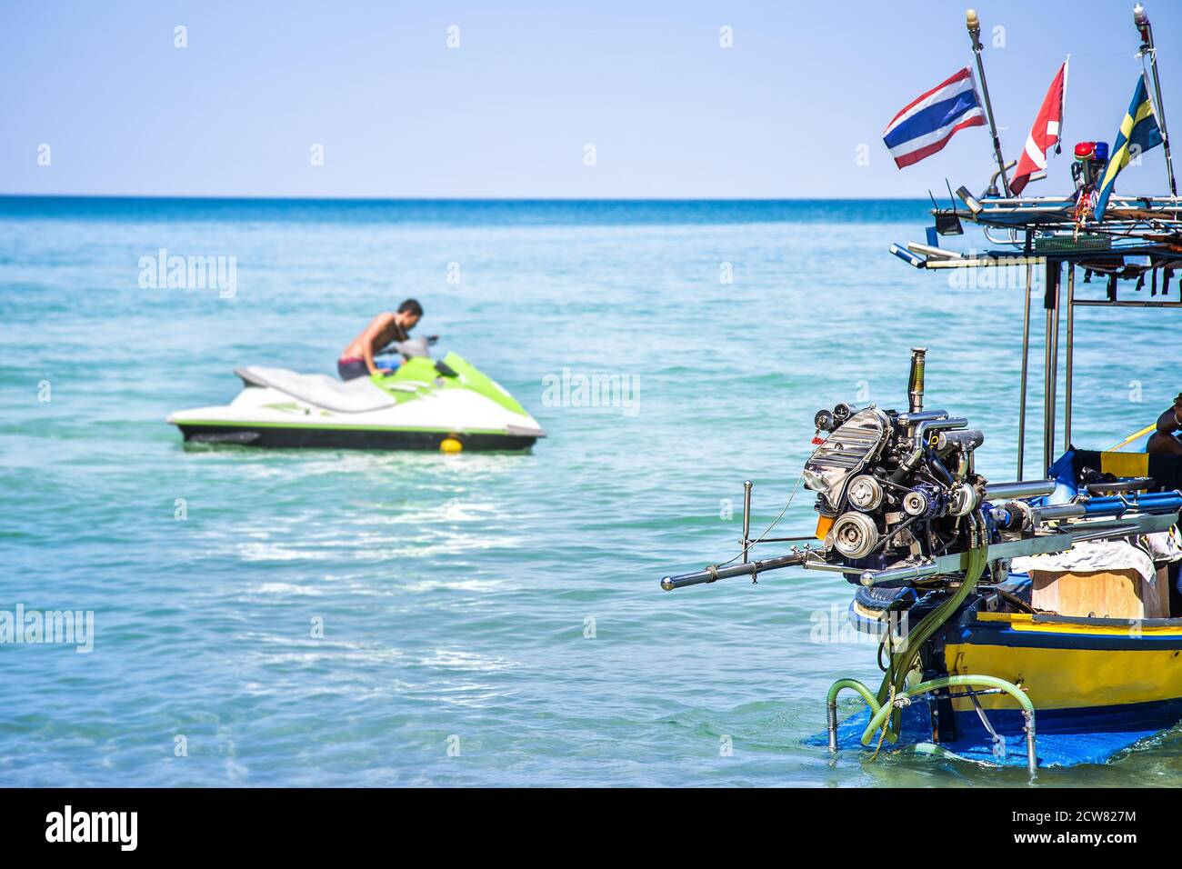 Shiny engine of motor wooden long tail boat. hydrocycle with man ...