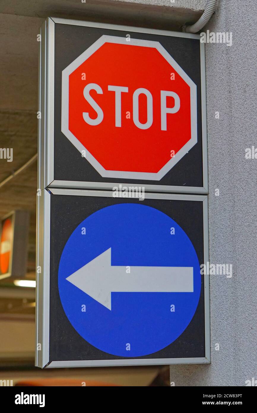 Stop sign and direction arrow at garage entrance Stock Photo - Alamy