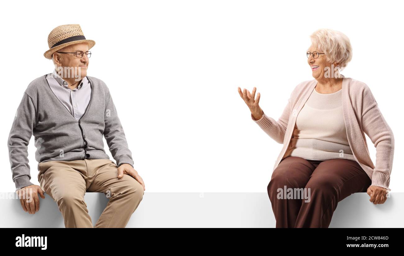 Seniors talking and sitting on a blank panel isolated on white ...