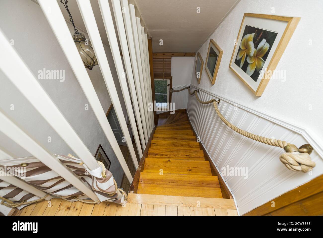 Close up view of wooden descending stairs with white railings. Interior ...