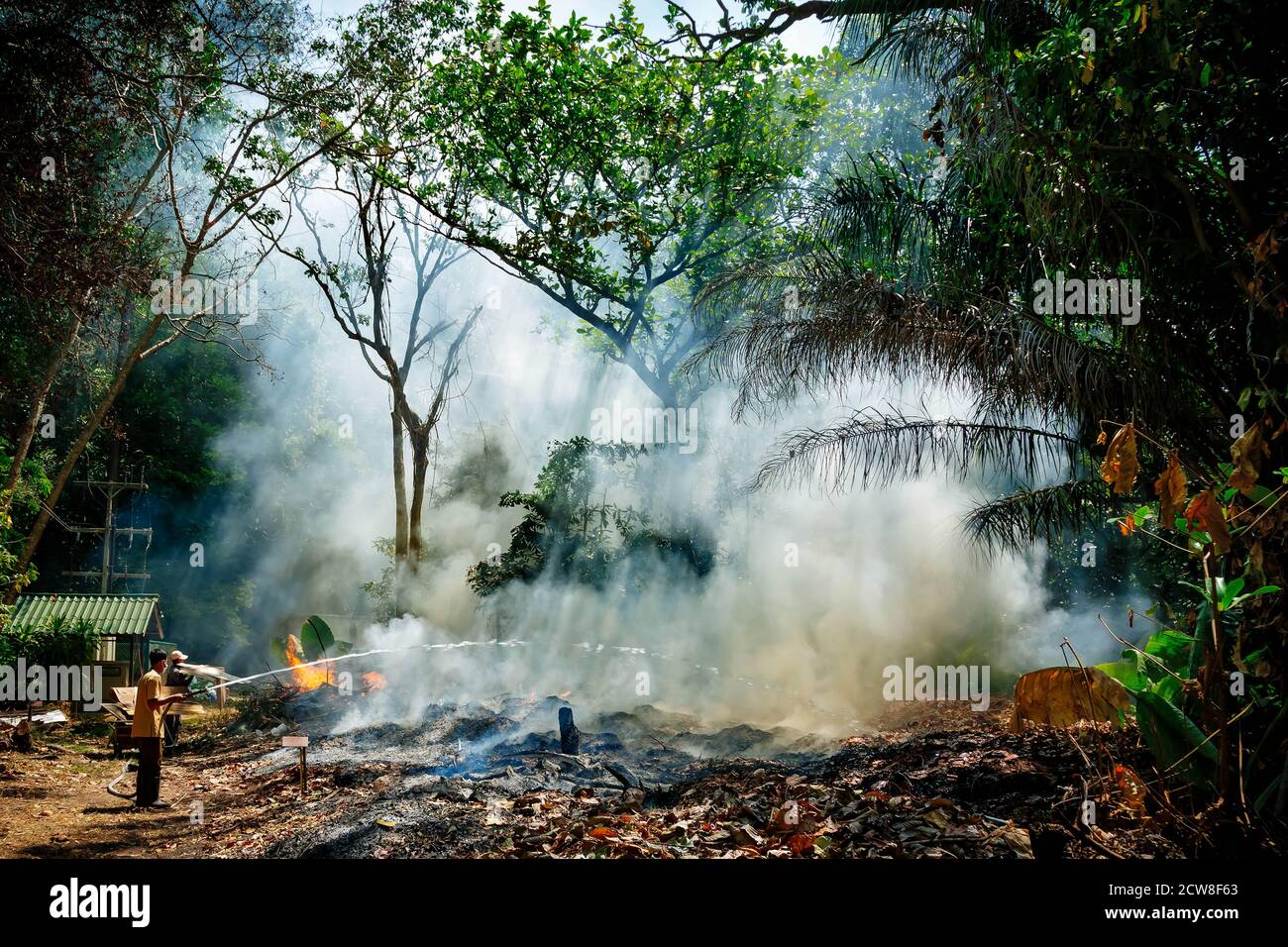 A man in a gauze bandage and a fire hose trying to put out the fire in ...