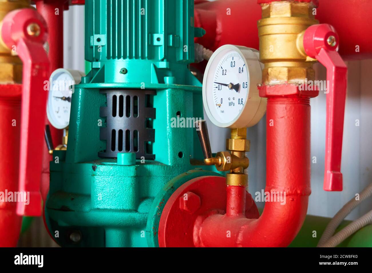 Green electric motor with pump on hot water pipeline with pressure ...