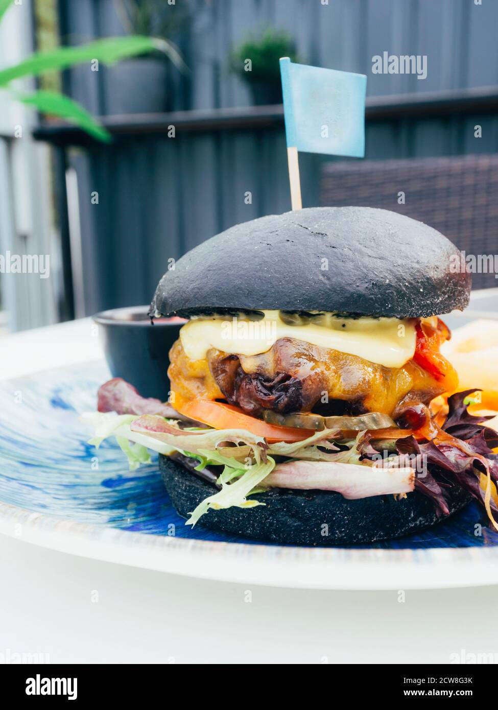 Modern delicious black burger with meat, bun, lettuce, cheese, ketchup ...